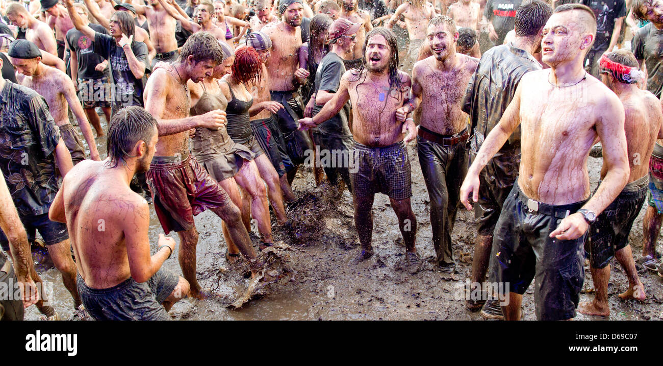 Festival visitors enjoy dancing in the mud at the music festival ...
