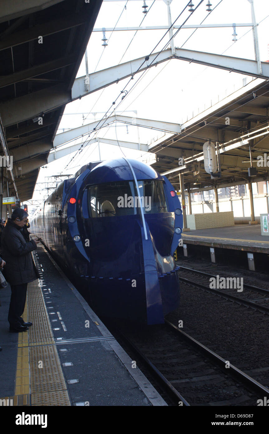This image features a blue train traveling on the Nankai Dentetsu line ...