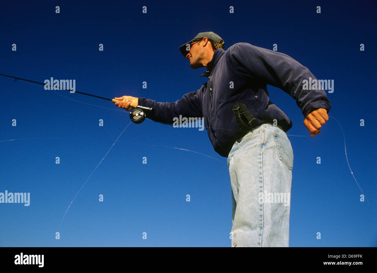 A fly fisherman casting for striped bass and bluefish at Cape Cod ...