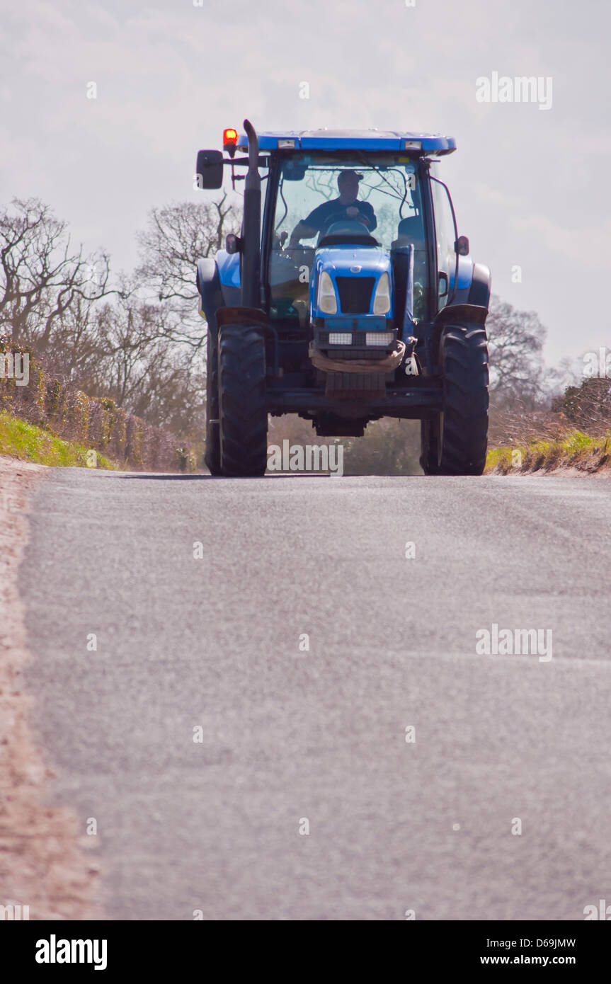Farm tractor on country lane road Stock Photo - Alamy