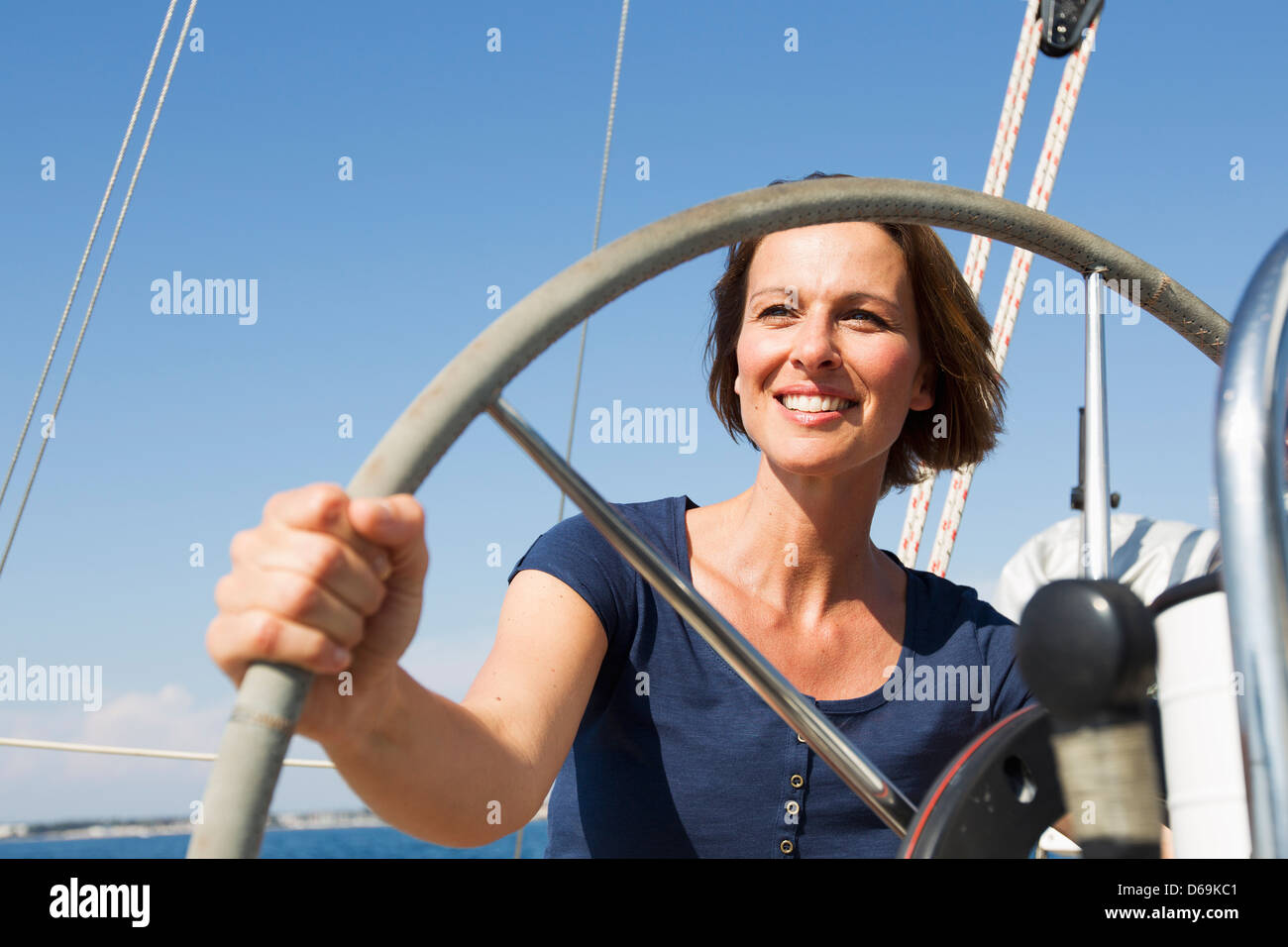 Smiling woman driving boat Stock Photo - Alamy