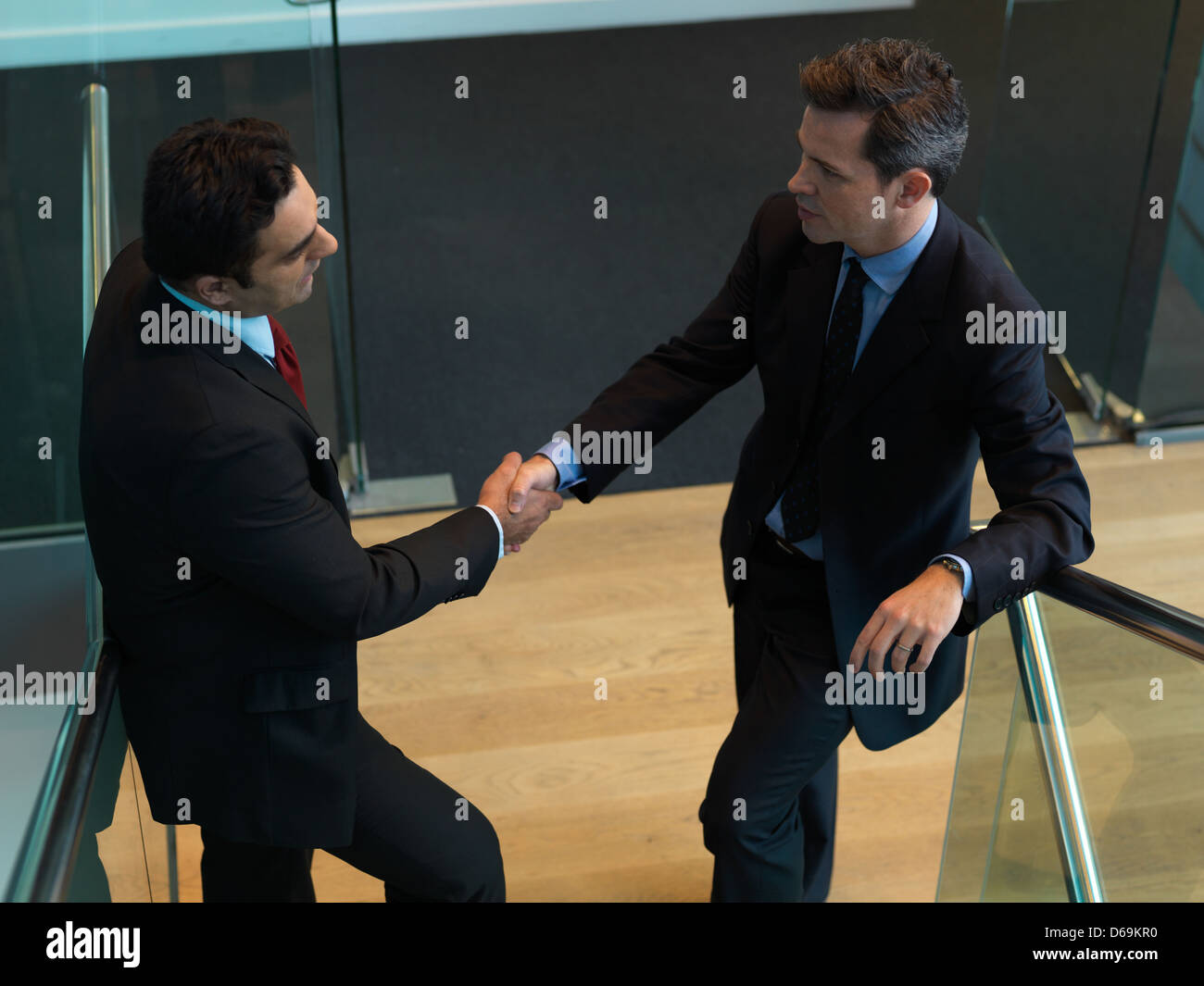 Businessmen shaking hands in office Stock Photo - Alamy