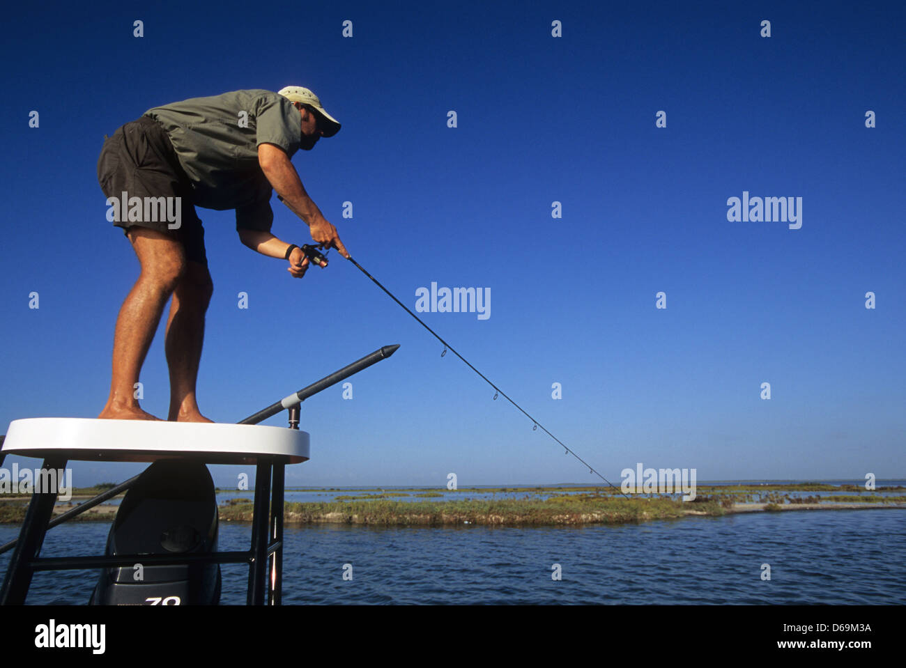Fly fisherman and fishing guide poling their skiff and looking for ...