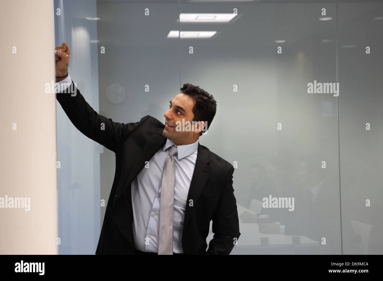 Businessman writing on whiteboard Stock Photo - Alamy