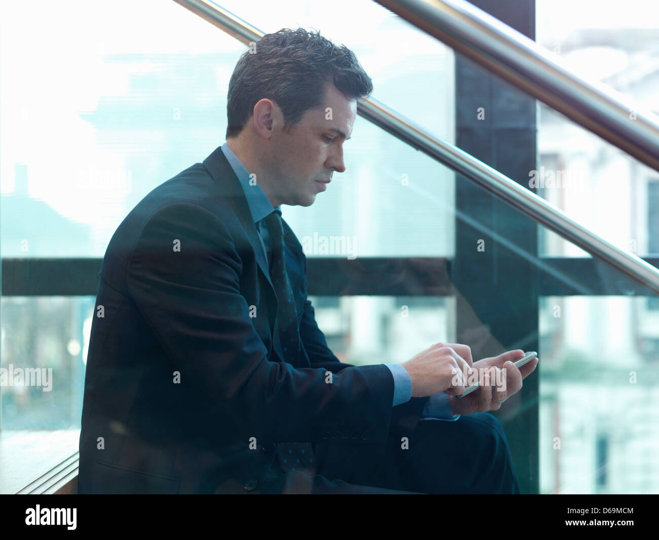 Businessman using cell phone in office Stock Photo - Alamy