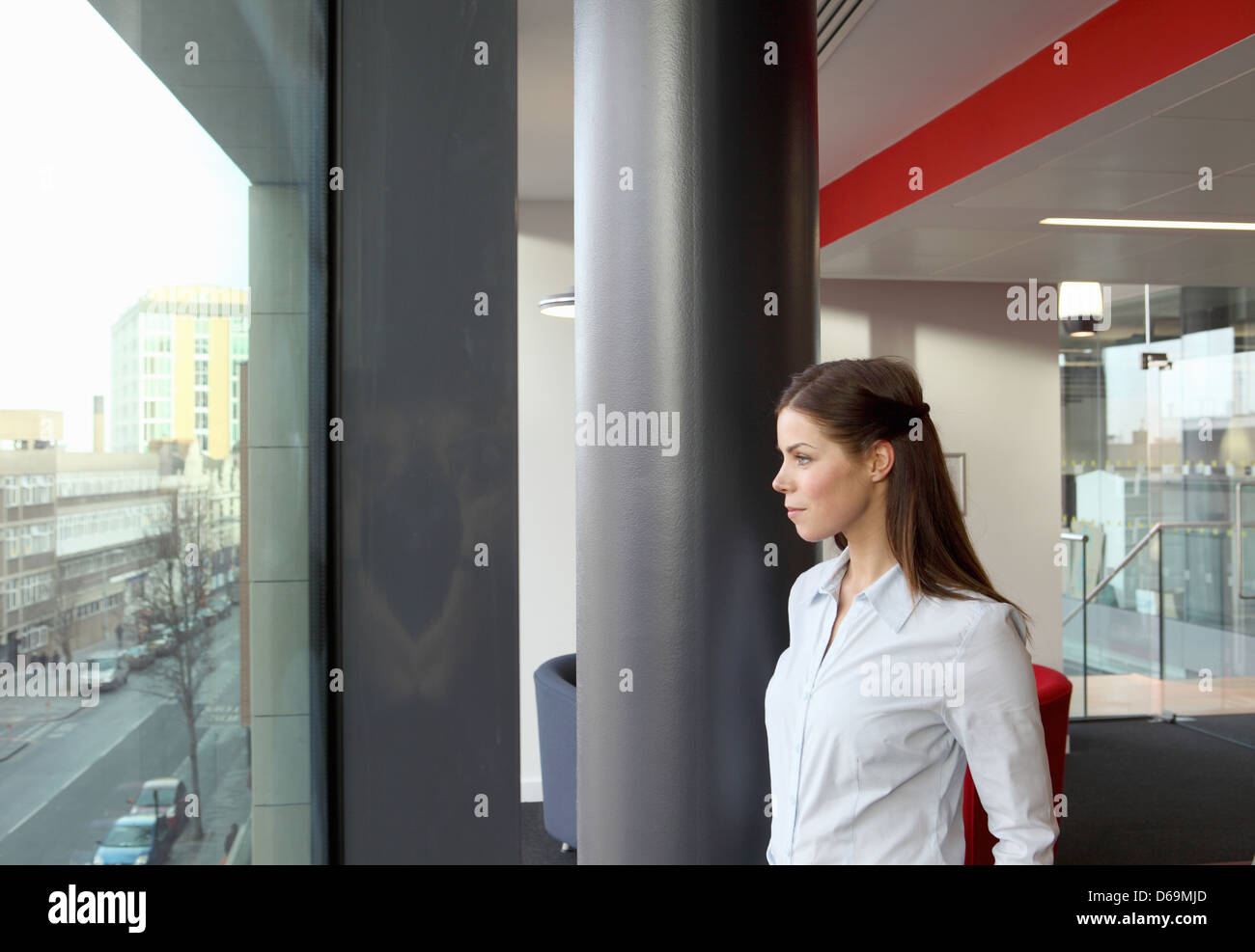 Businesswoman looking out office window Stock Photo - Alamy