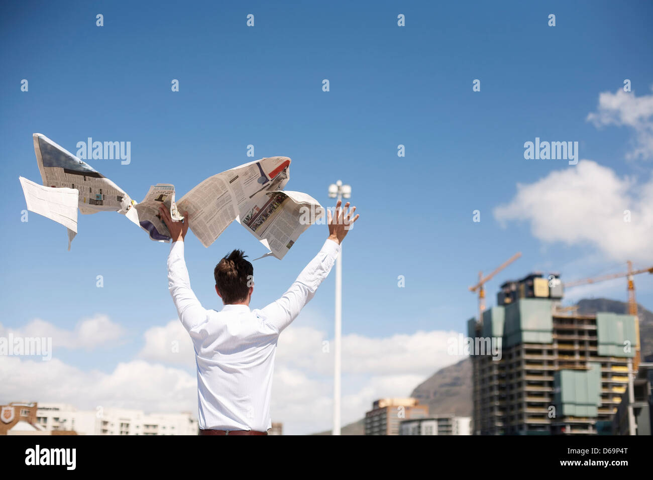 Businessman throwing newspaper in air Stock Photo - Alamy