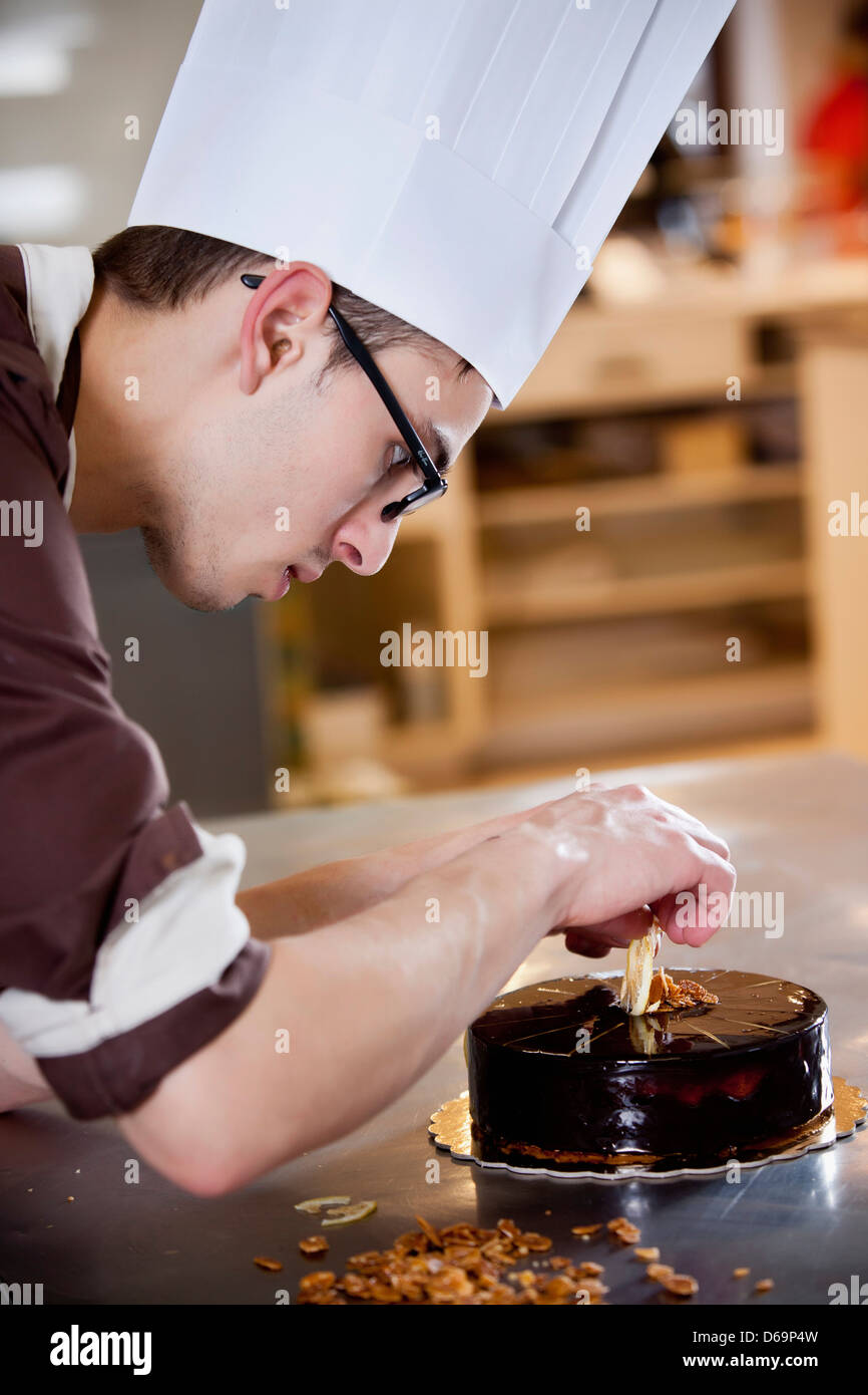 Baker decorating cake in kitchen Stock Photo - Alamy