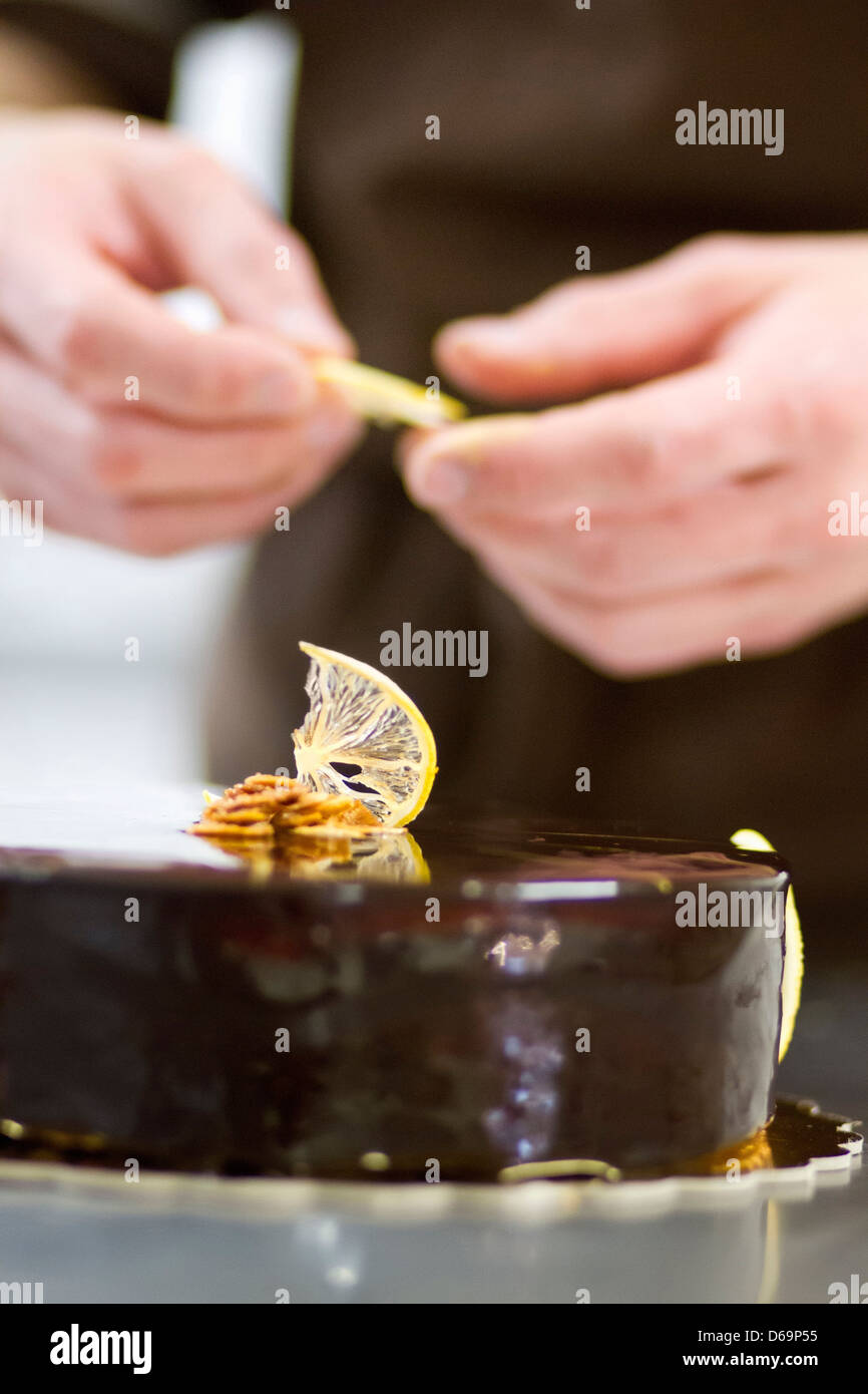 Baker decorating cake in kitchen Stock Photo - Alamy