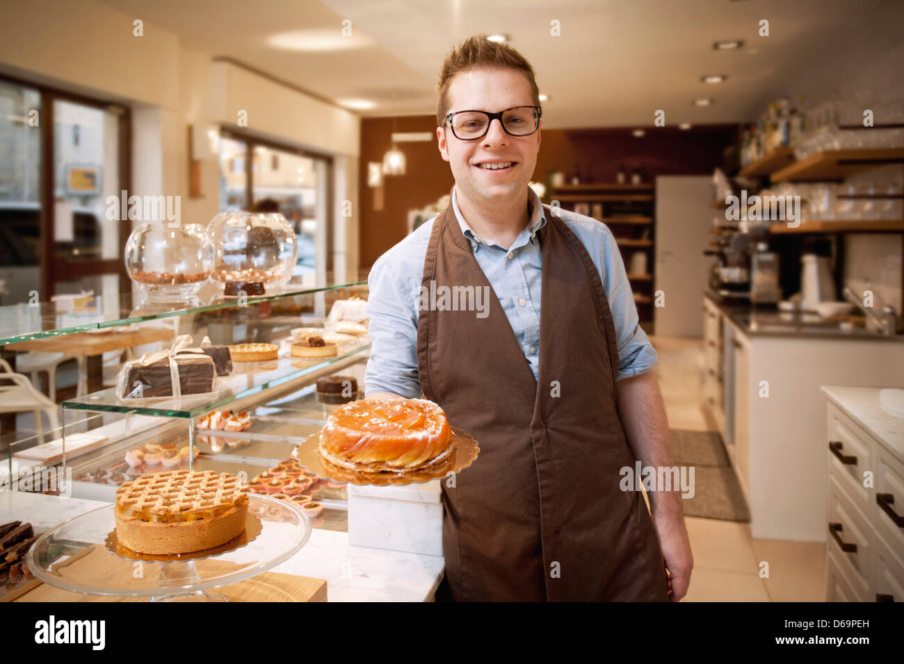 Cashier holding fruit cake in bakery Stock Photo - Alamy