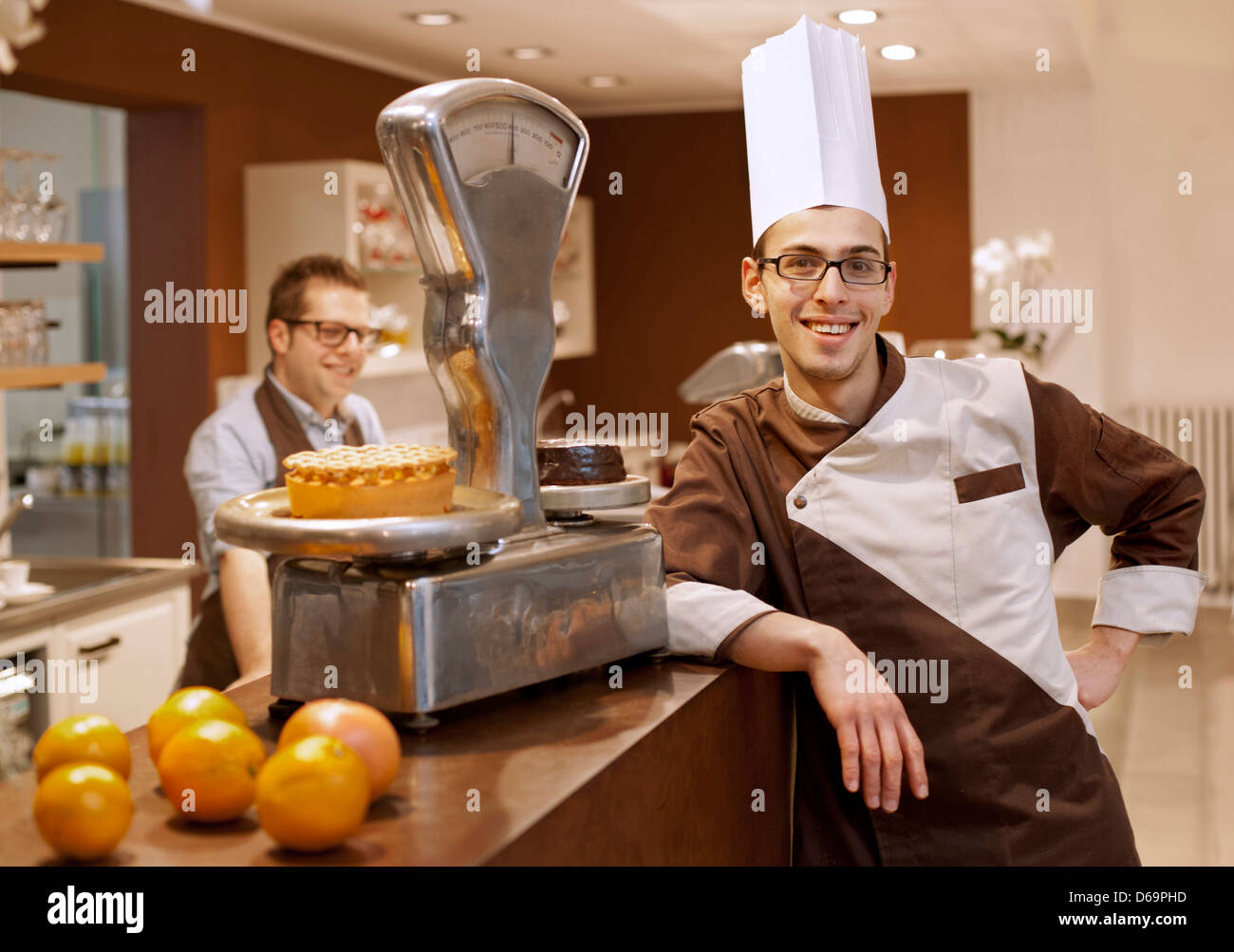 Baker weighing cakes on scales Stock Photo - Alamy