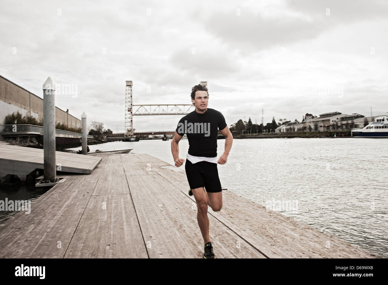 Man running on urban waterfront Stock Photo - Alamy