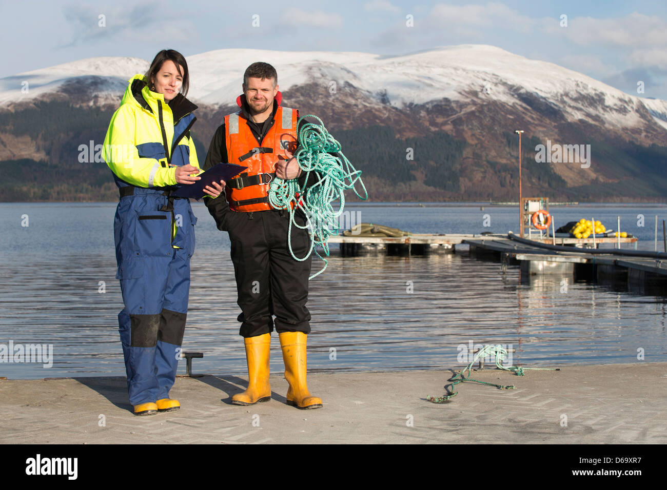 Workers on salmon farm in rural lake Stock Photo - Alamy