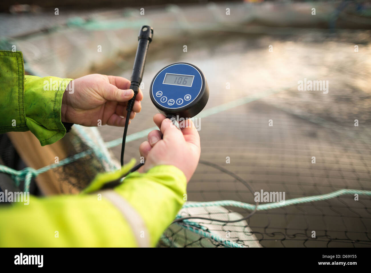 Worker on salmon farm in rural lake Stock Photo - Alamy
