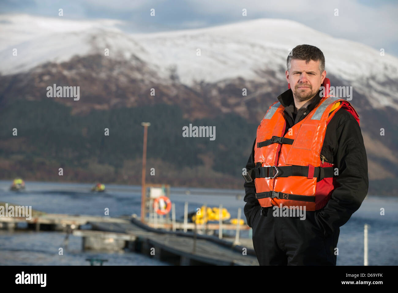 Worker smiling on salmon farm Stock Photo - Alamy