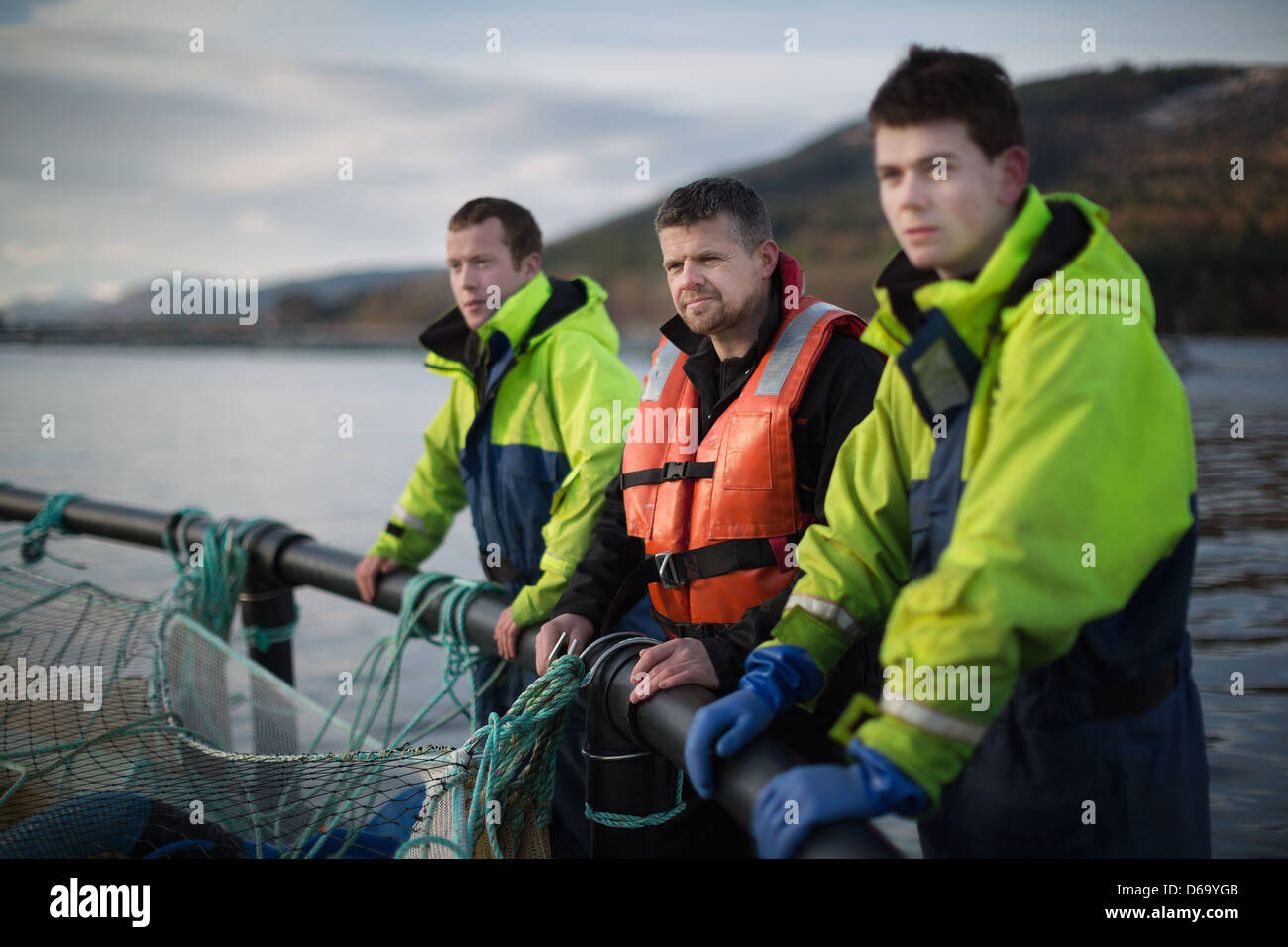 Workers at salmon farm in rural lake Stock Photo - Alamy