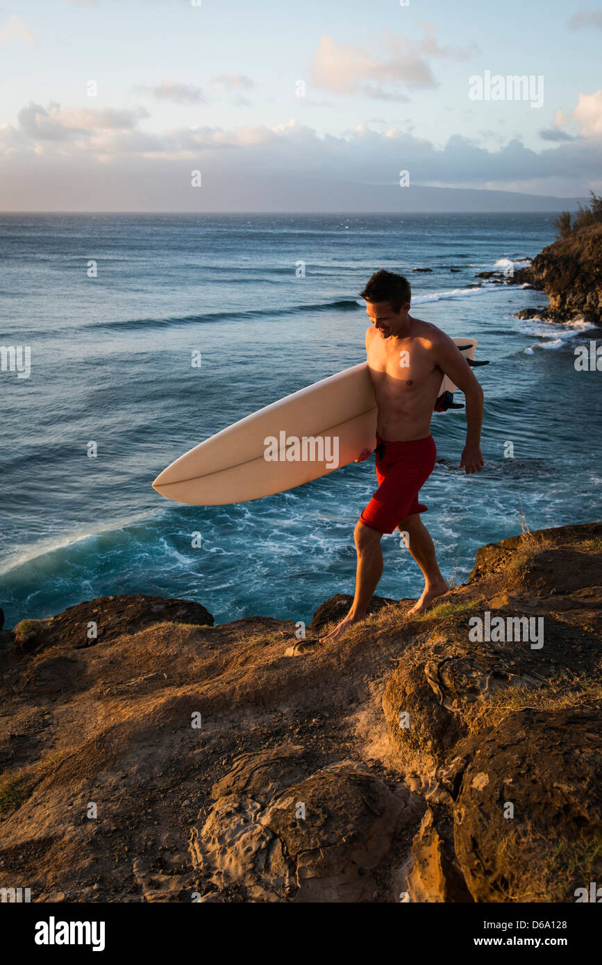 Surfer carrying board on beach Stock Photo - Alamy