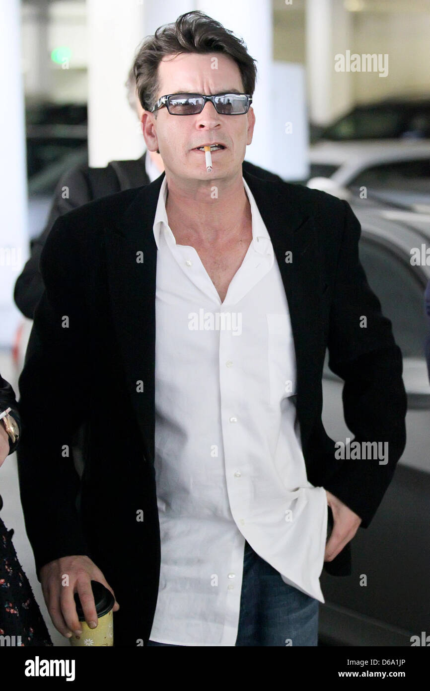 Charlie Sheen smoking a cigarette as he leaves an office building in ...