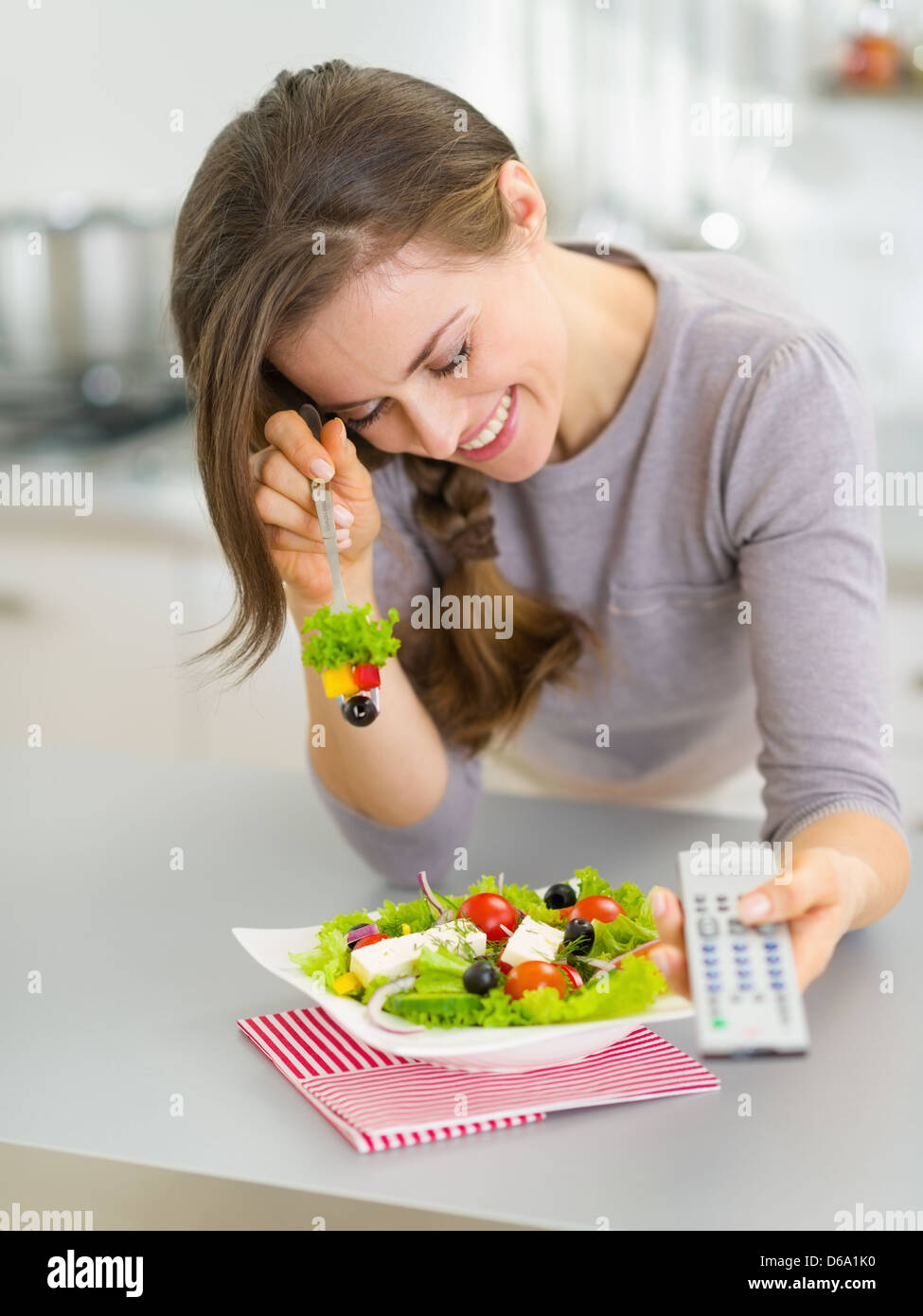 Woman Eating Salad While Laughing