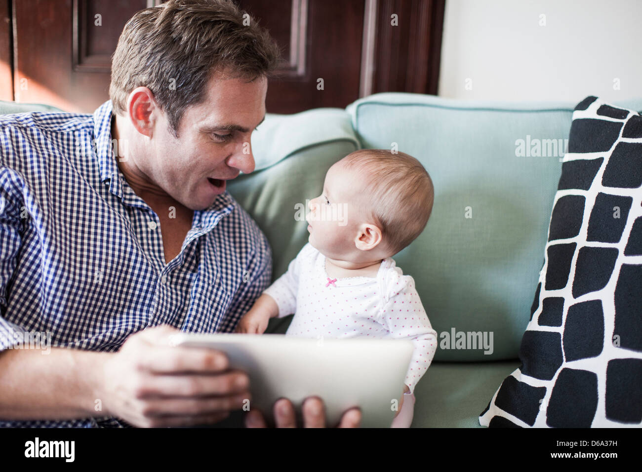 Father using tablet with baby daughter Stock Photo - Alamy