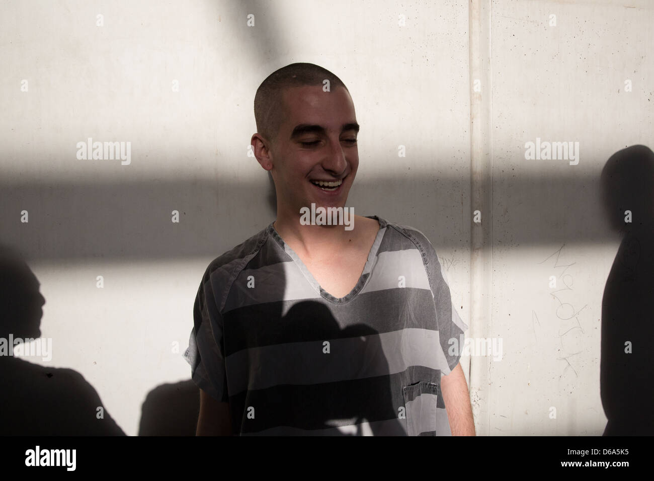 A male inmate laughs while waiting to get his prison id photograph ...