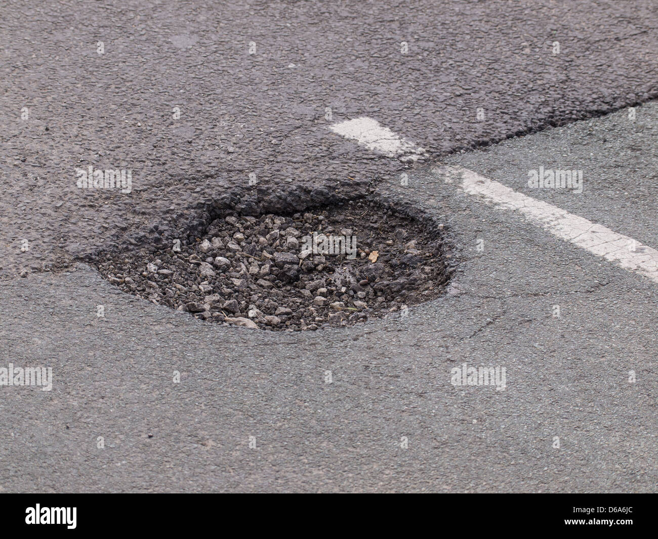 large pothole in tarmac road after bad weather Stock Photo - Alamy