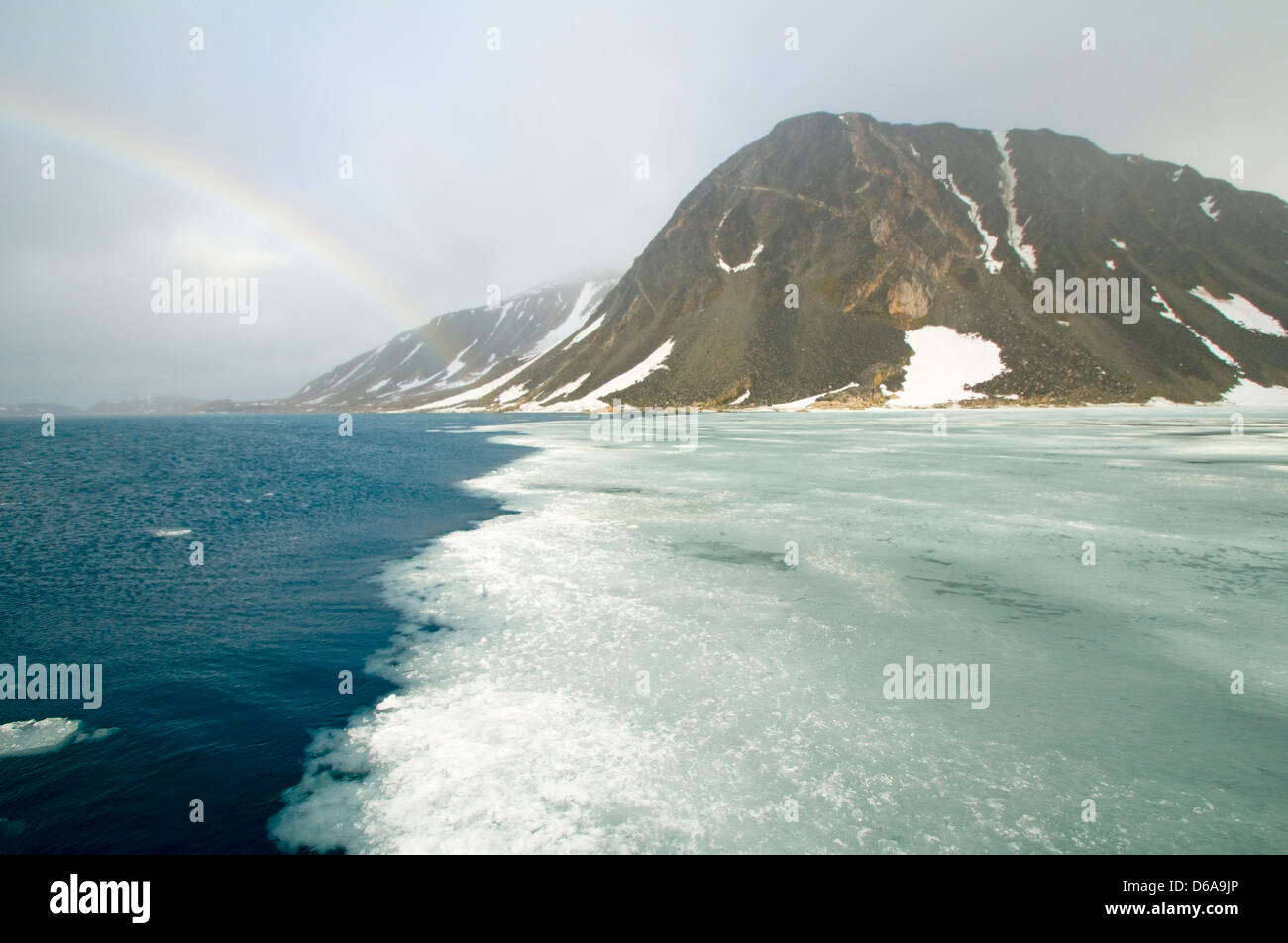Norway, Svalbard Archipelago, Spitsbergen. Rainbow over fjord ice and a ...
