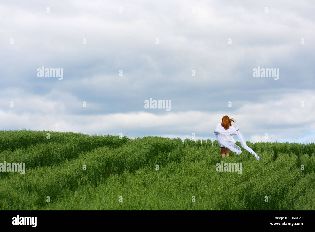 Woman walking in a field Stock Photo - Alamy