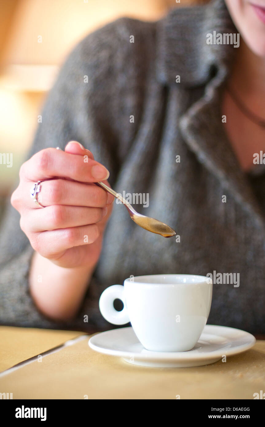 Woman Lifting Spoon From Coffee Cup Stock Photo - Alamy
