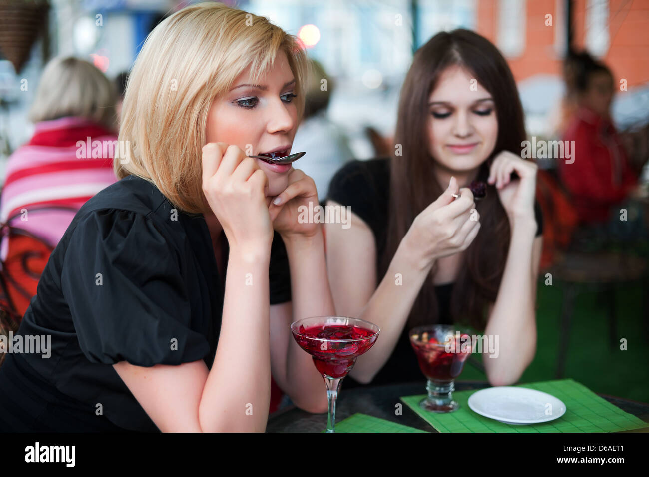 Two young women eating a dessert Stock Photo - Alamy