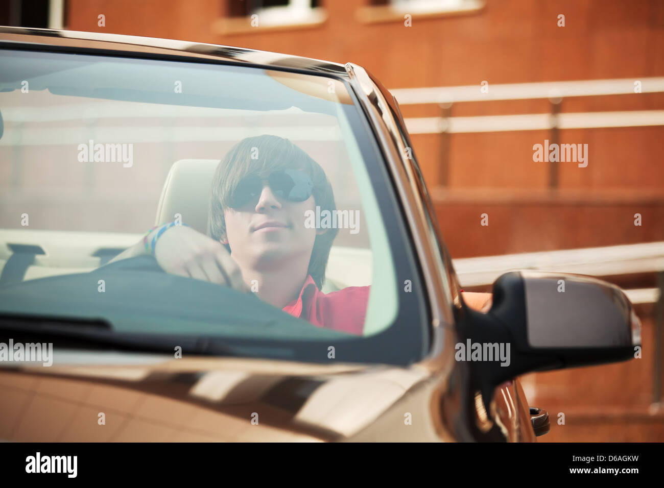 Young man driving a convertible car Stock Photo - Alamy