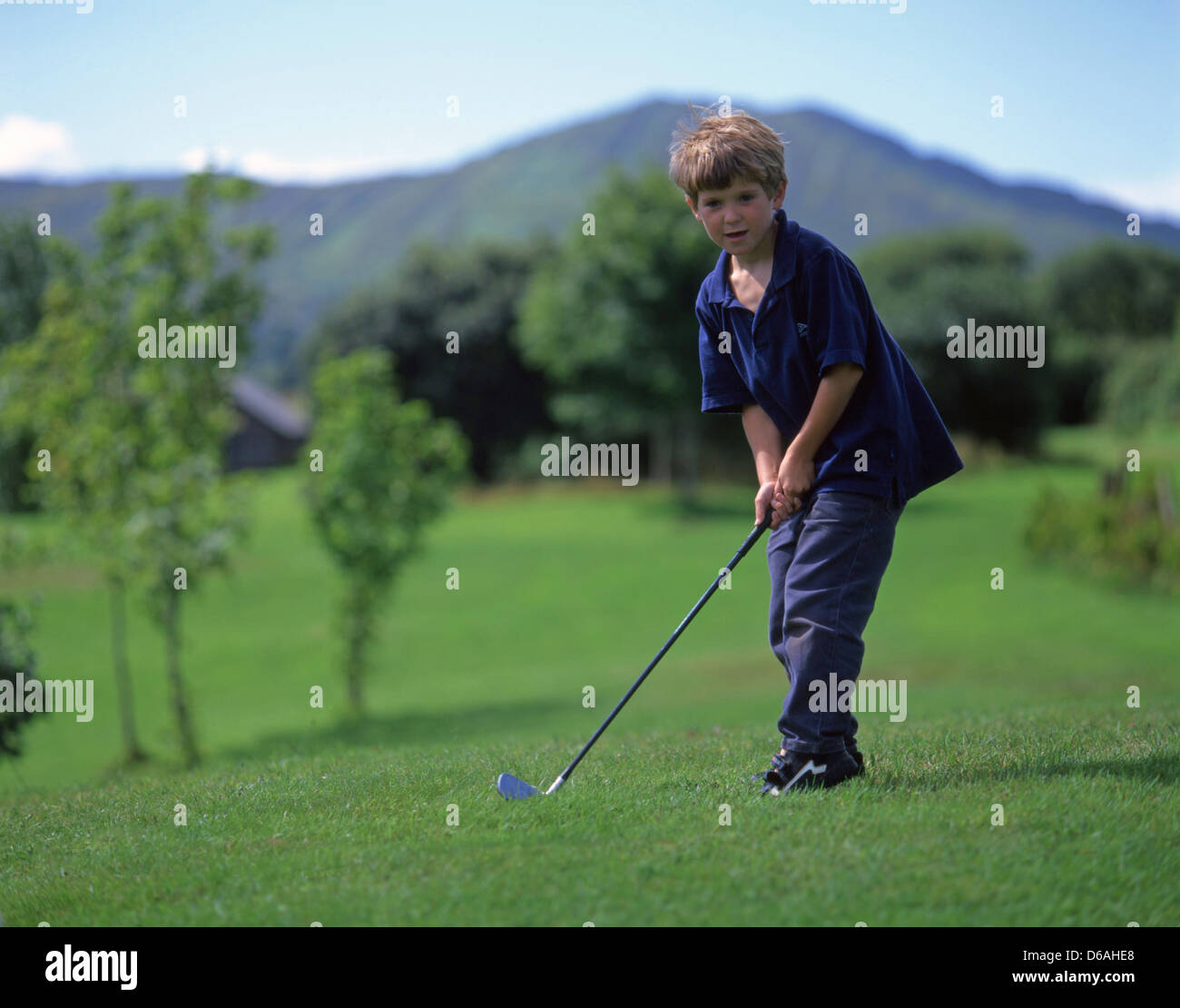 Young boy playing golf on golf-course, Winkfield, Berkshire, England ...