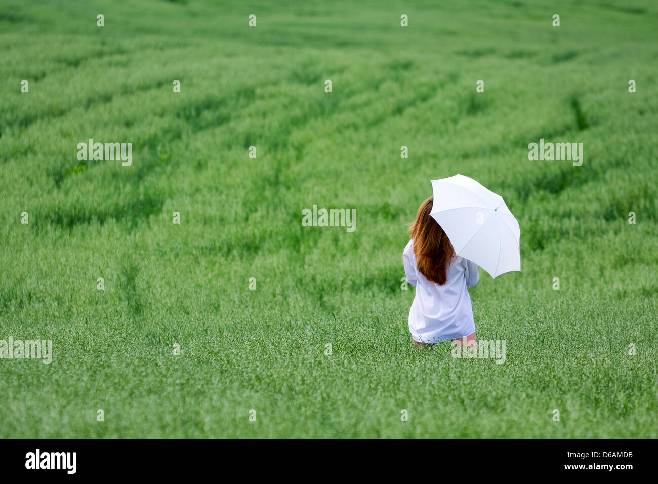 Young woman walking in a field Stock Photo - Alamy