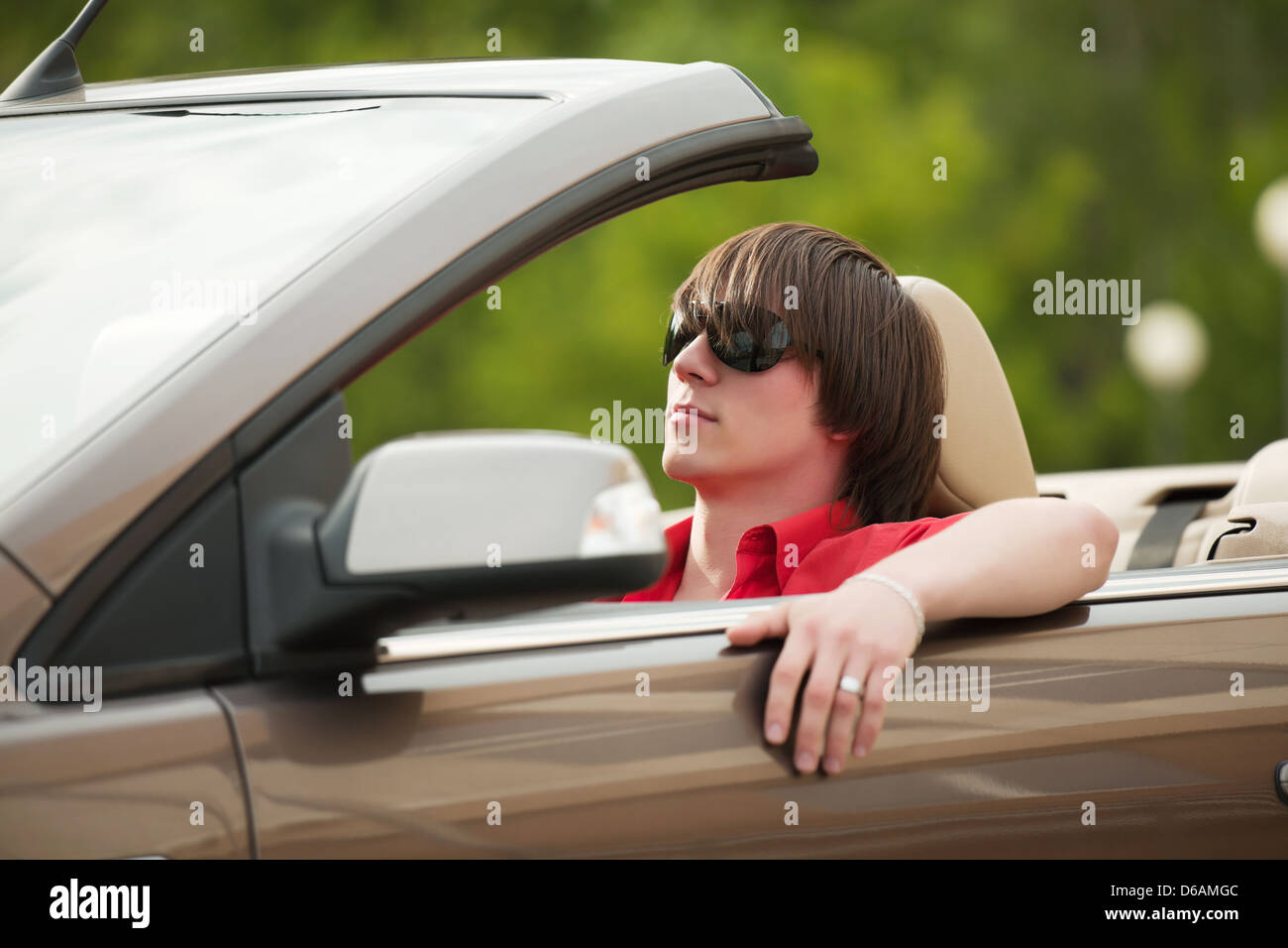 Young man driving a convertible car Stock Photo - Alamy