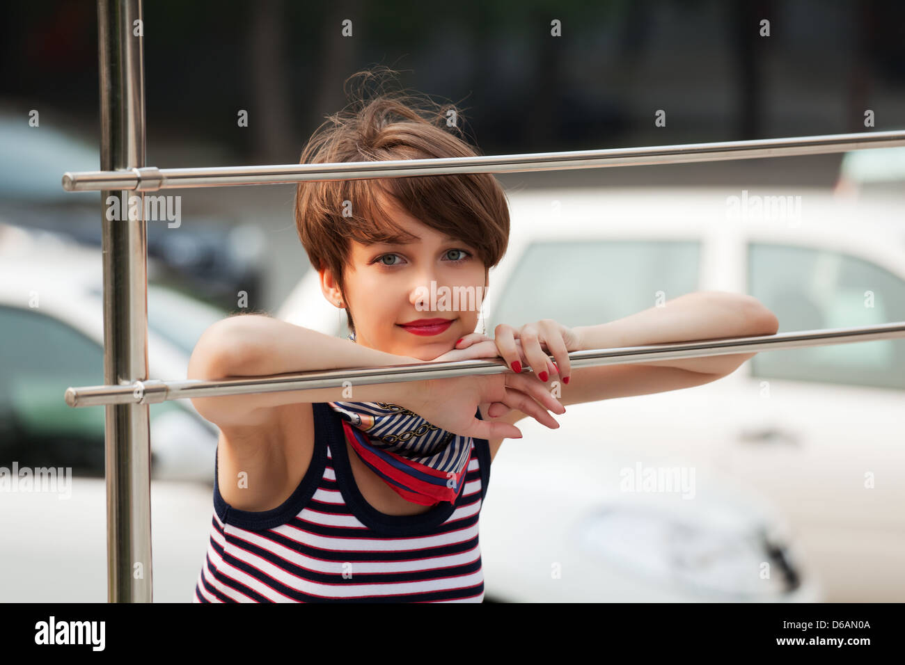 Happy young woman against a car parking Stock Photo - Alamy