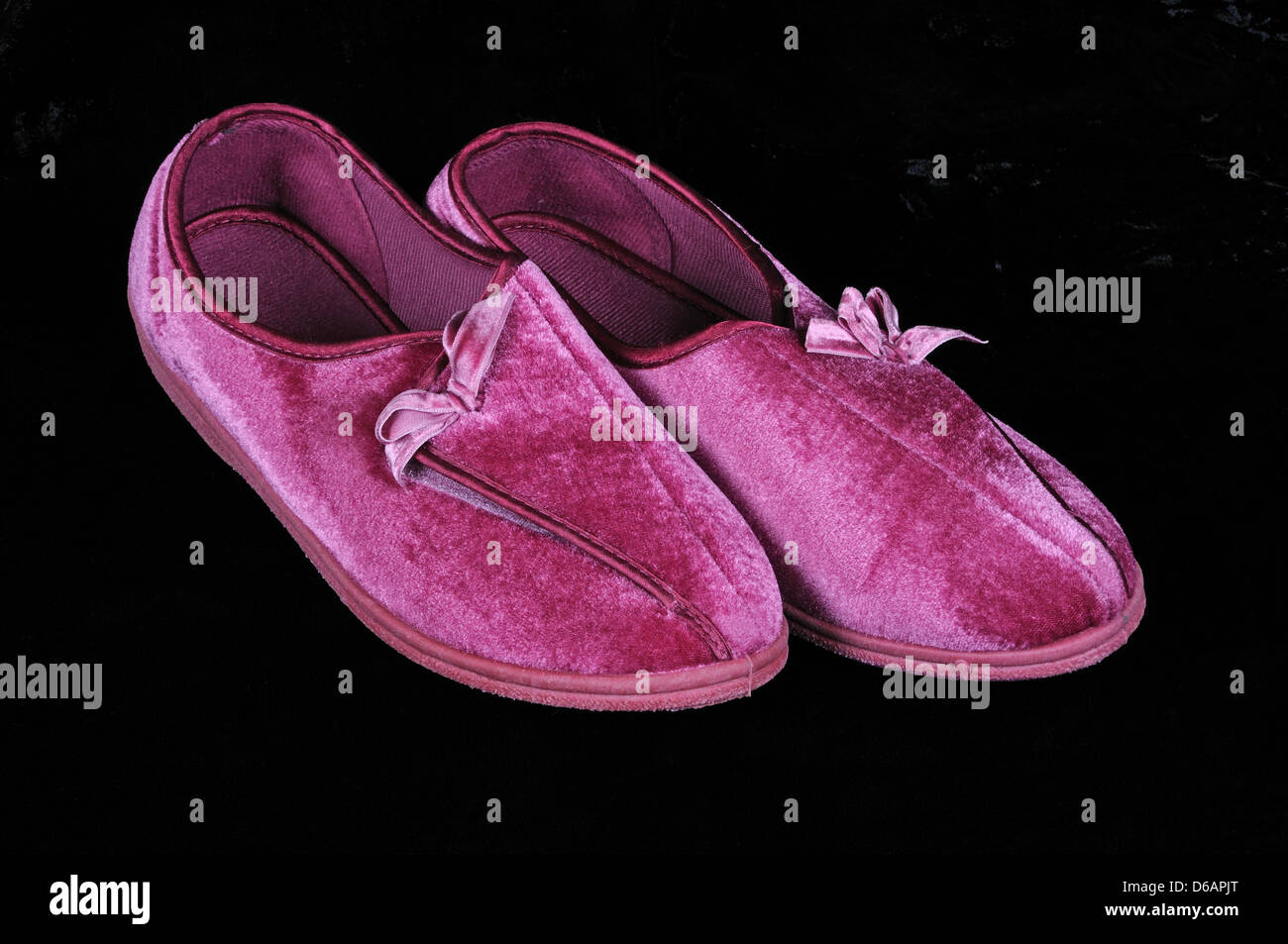 Womans deep pink slippers against a black background Stock Photo - Alamy