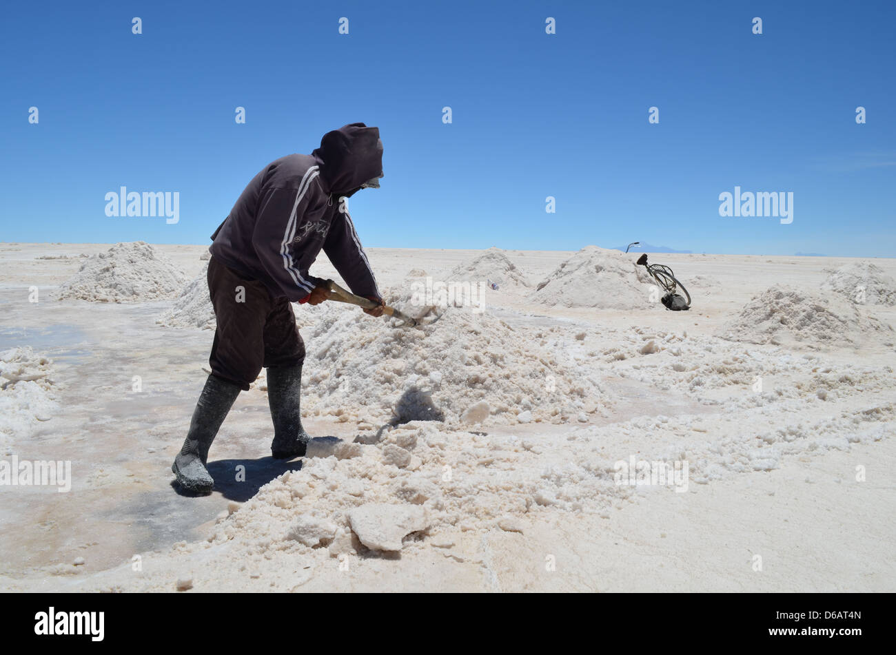 Local man working to collect salt to sell. Salar de Uyuni, Bolivia ...