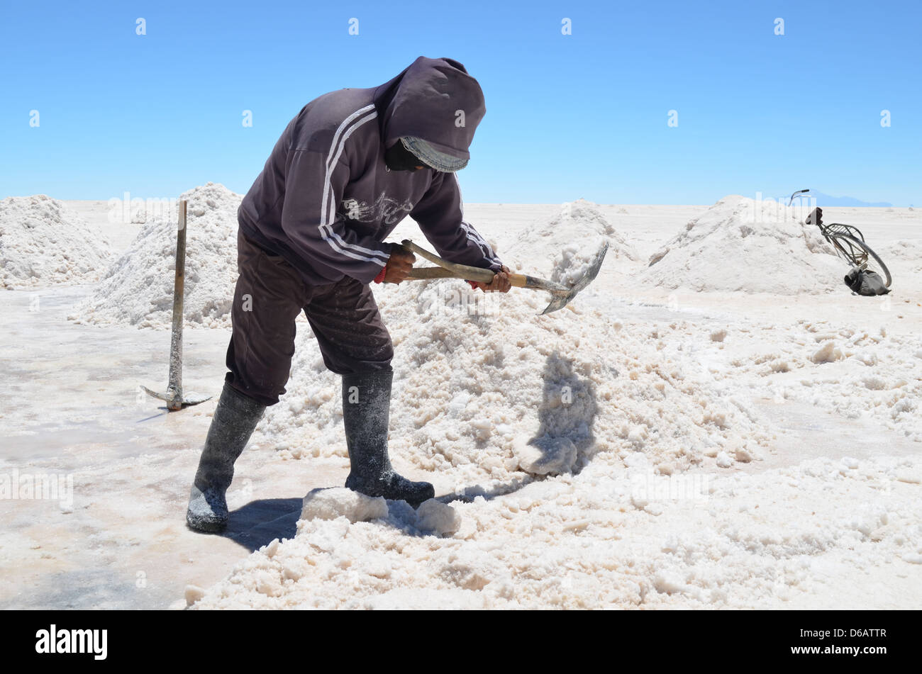 Local man working to collect salt to sell. Salar de Uyuni, Bolivia ...
