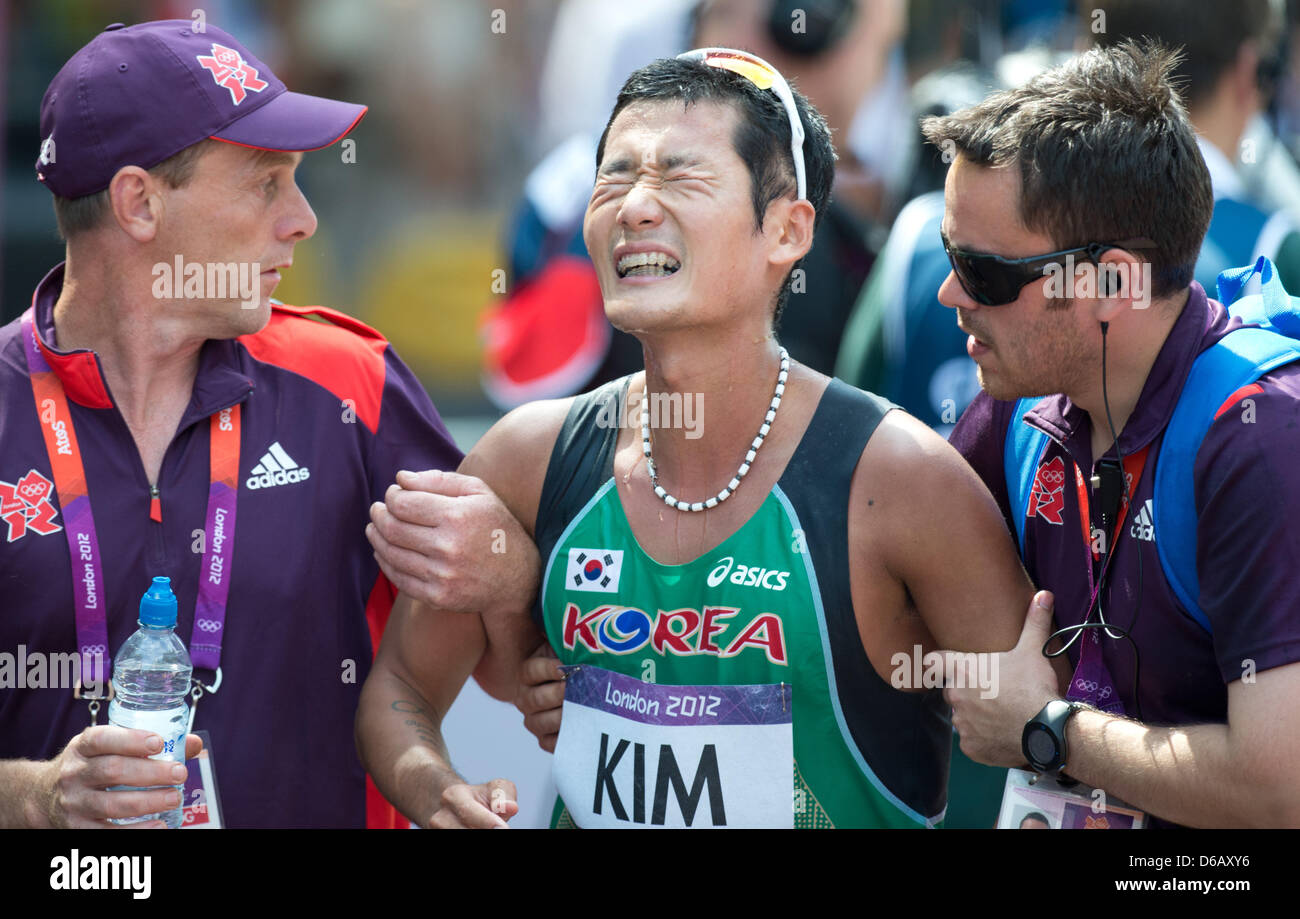 Dong-Young Kim of Korea is given assistance after he crosses the finish ...
