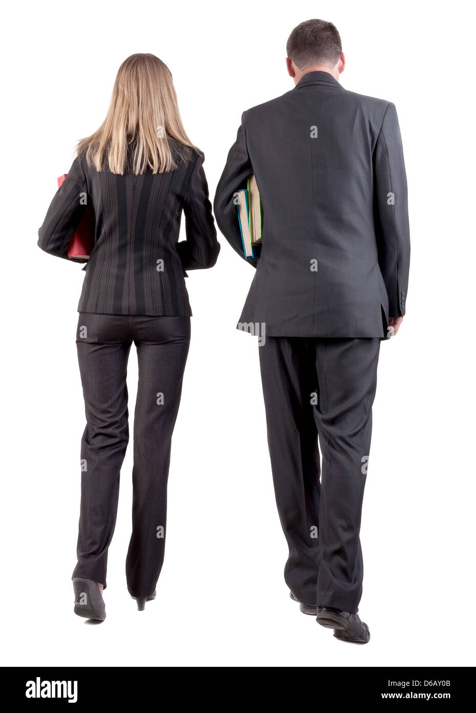 Back view of walking business team. Young couple in suit with books go ...