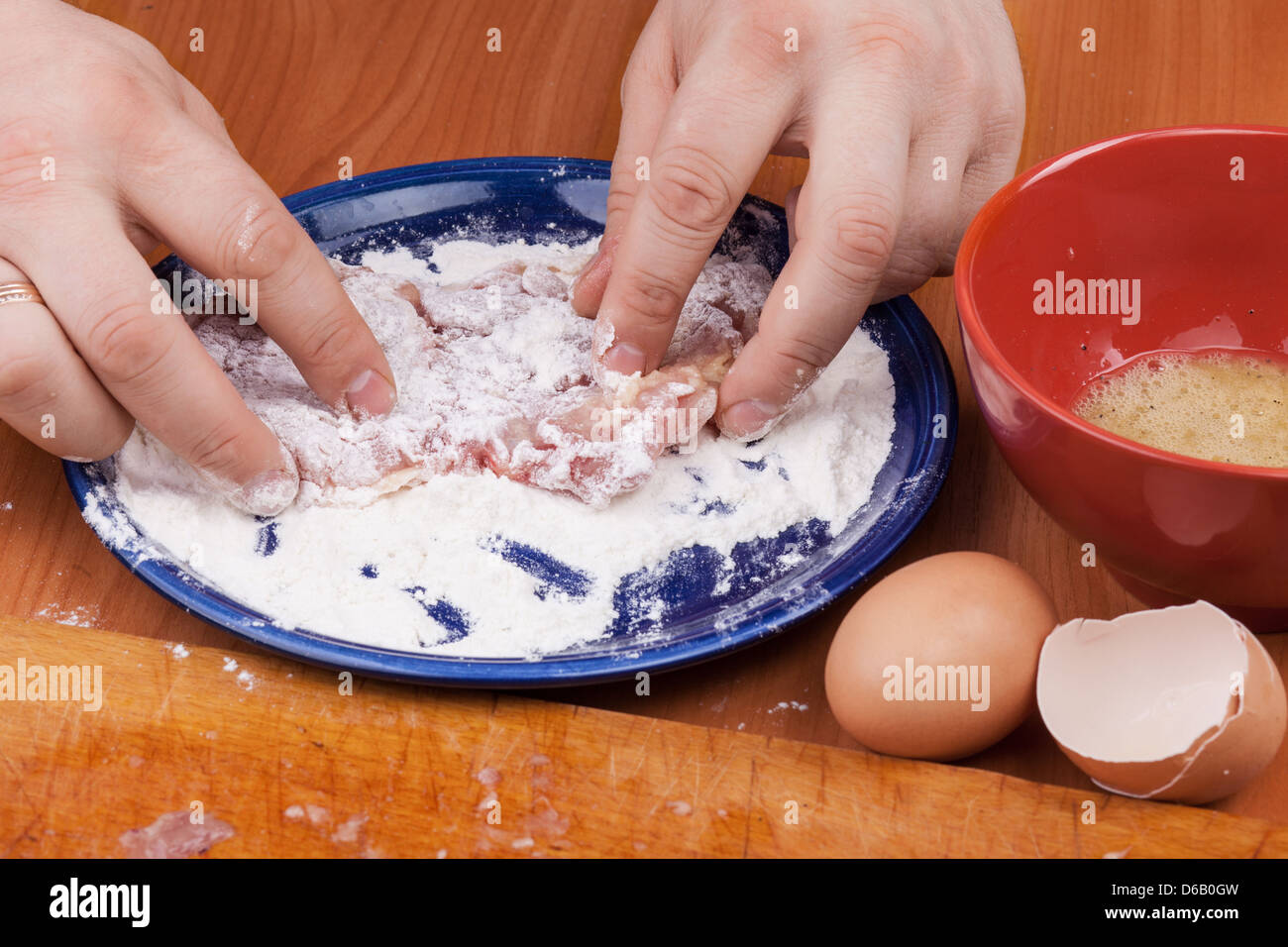 Cooking chicken thighs with a chop. Dipping into flour Stock Photo - Alamy