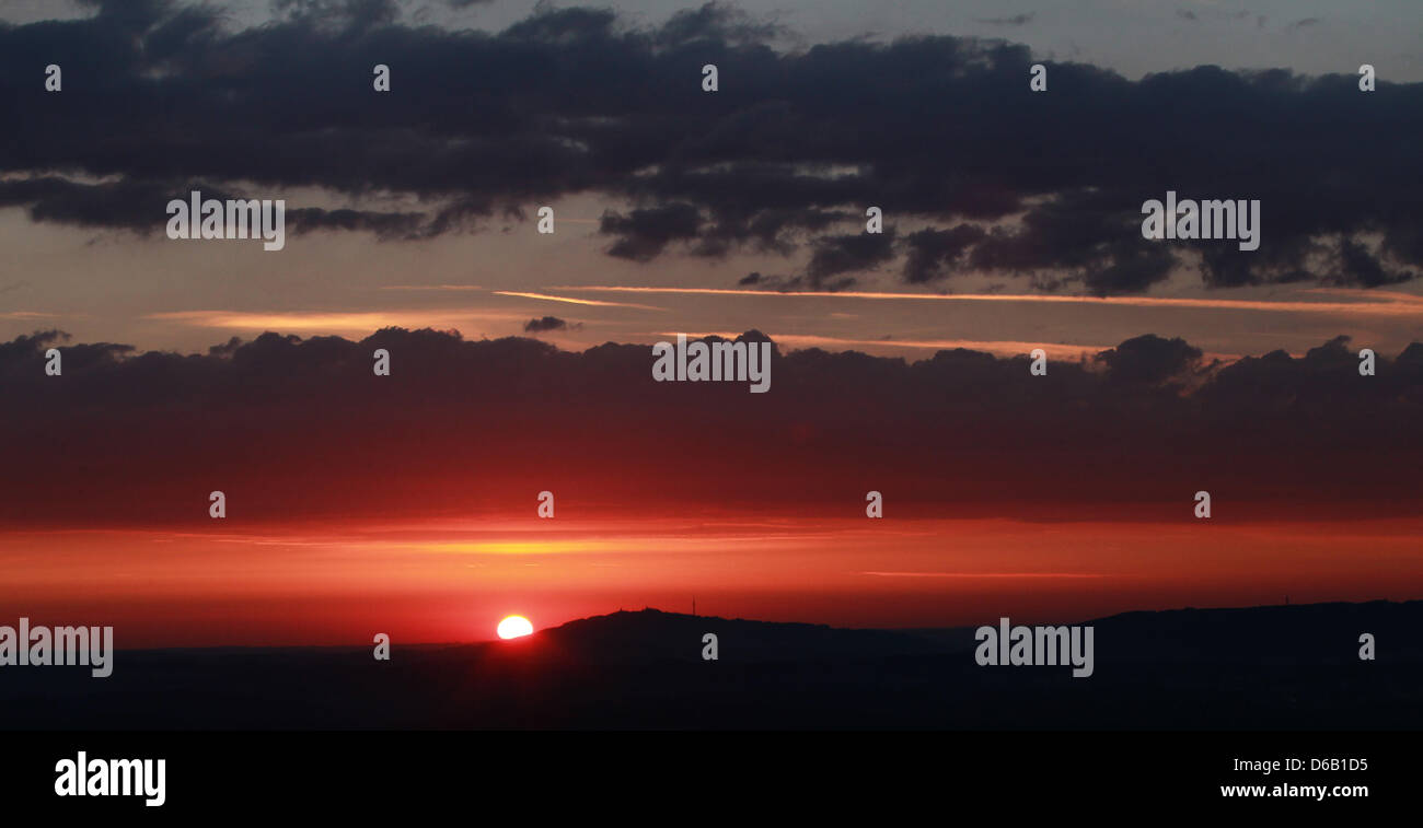 The rising sun illuminates the sky above the Hoher Peissenberg mountain ...
