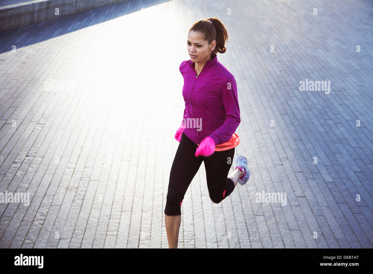 Woman running on city street Stock Photo - Alamy