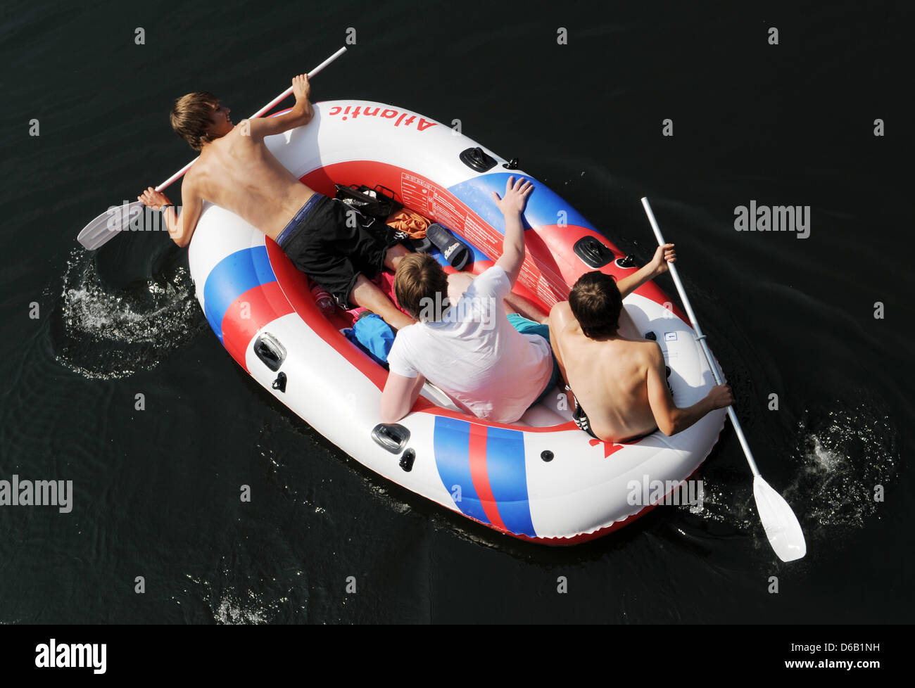 Three boys paddle in an inflatable raft at Edersee reservoir near ...