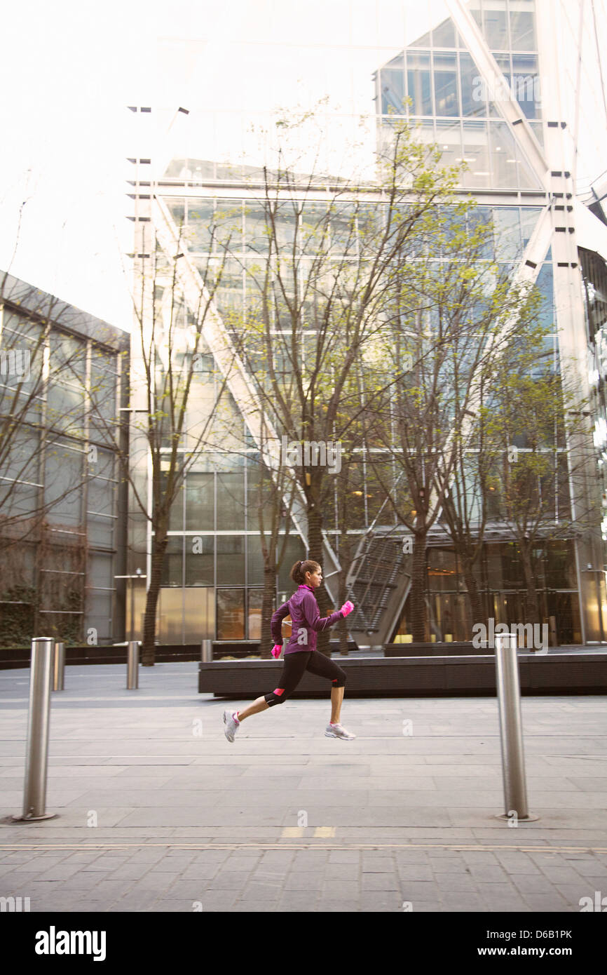Woman running on city street Stock Photo - Alamy