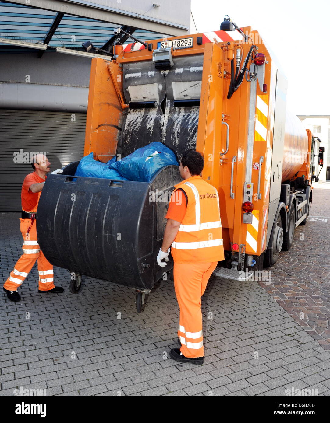 Stuttgart waste management workers load a garbage truck in Stuttgart ...