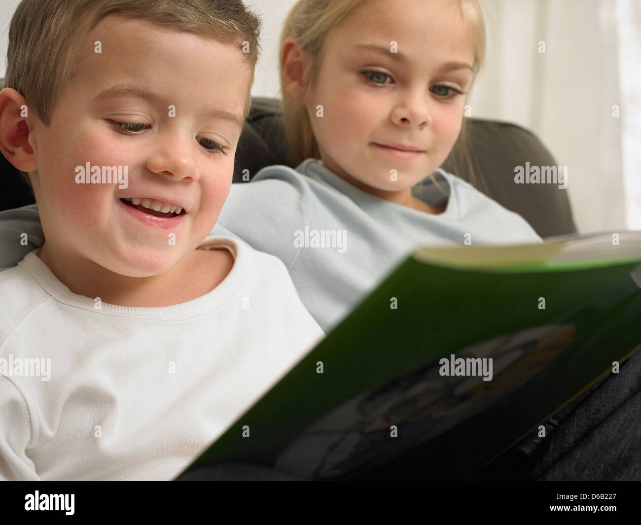 Children reading together on sofa Stock Photo - Alamy