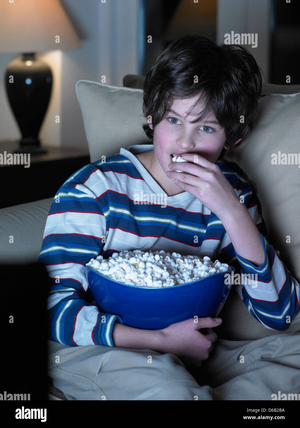 Boy eating popcorn in front of movie Stock Photo - Alamy