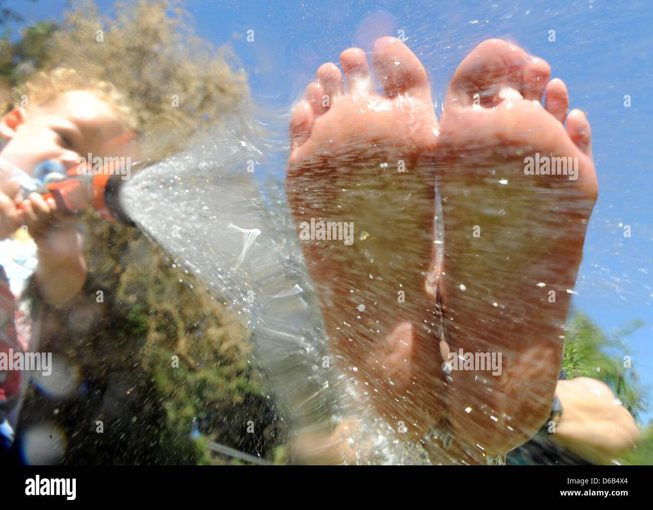 Two-year-old David showers the feet of his mother in Karlsruhe, Germany ...