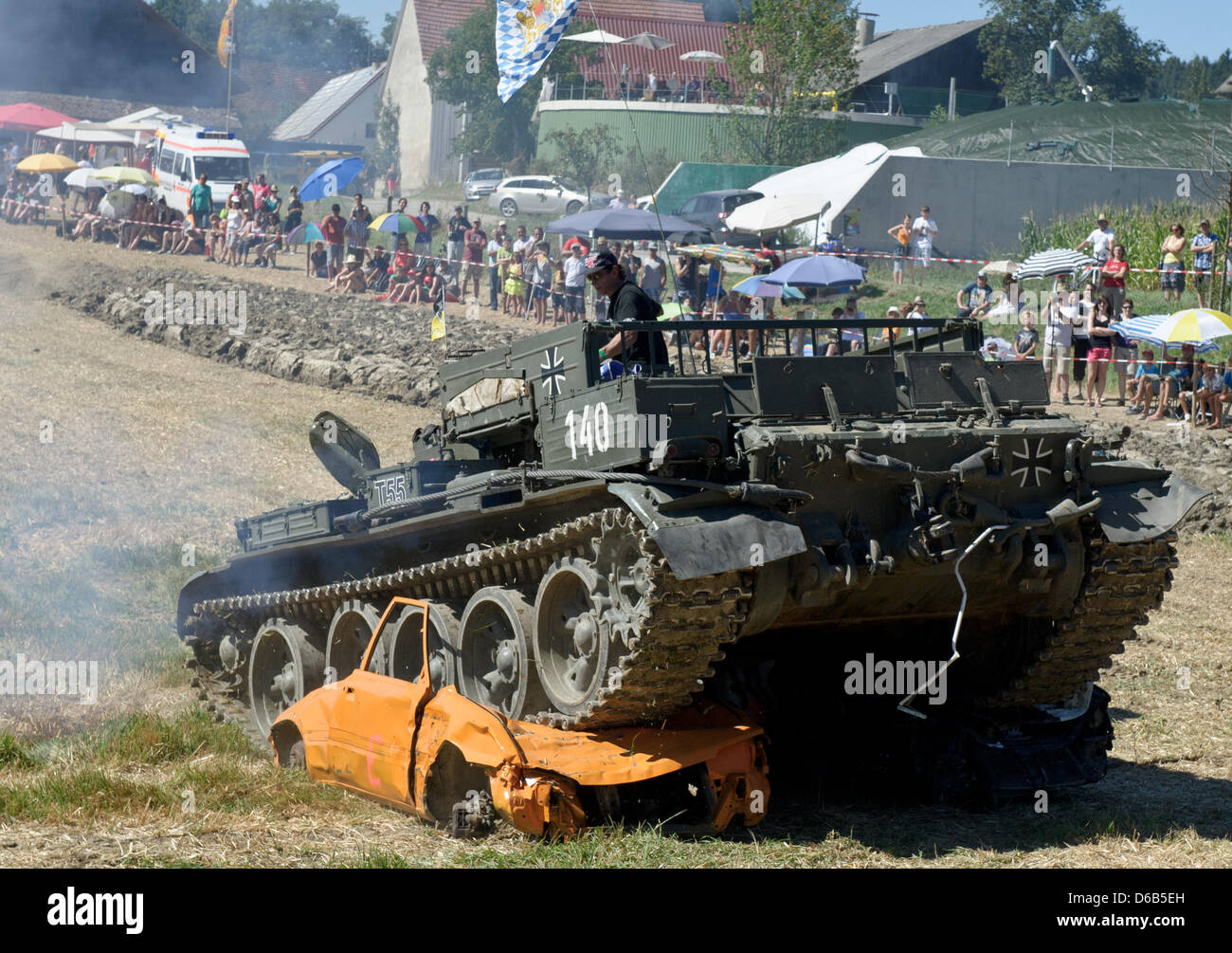 A decommissioned tanl drives over two scrap cars as intermission ...